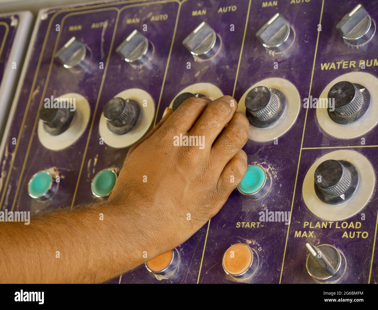 Asian male technician operating hydraulic machine at construction sight ...