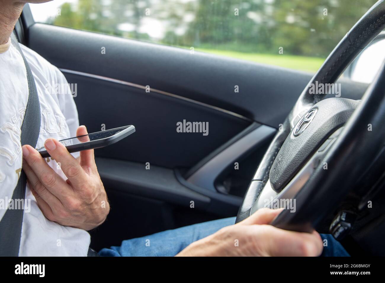 Symbol image of a mobile phone at the wheel: Man talking on the phone ...