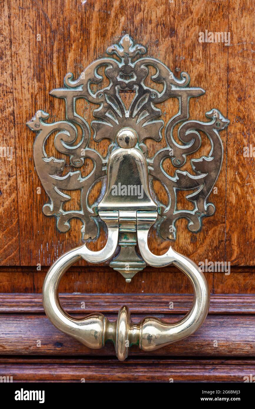Ornate metal knocker affixed to a wooden door. Paris Stock Photo - Alamy