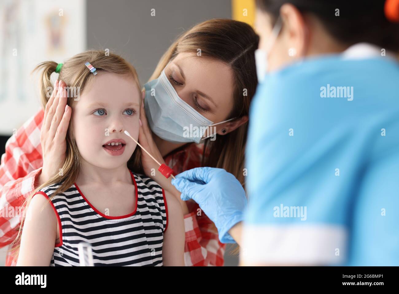 Doctor taking pcr swab from nose of little girl using cotton swab at ...