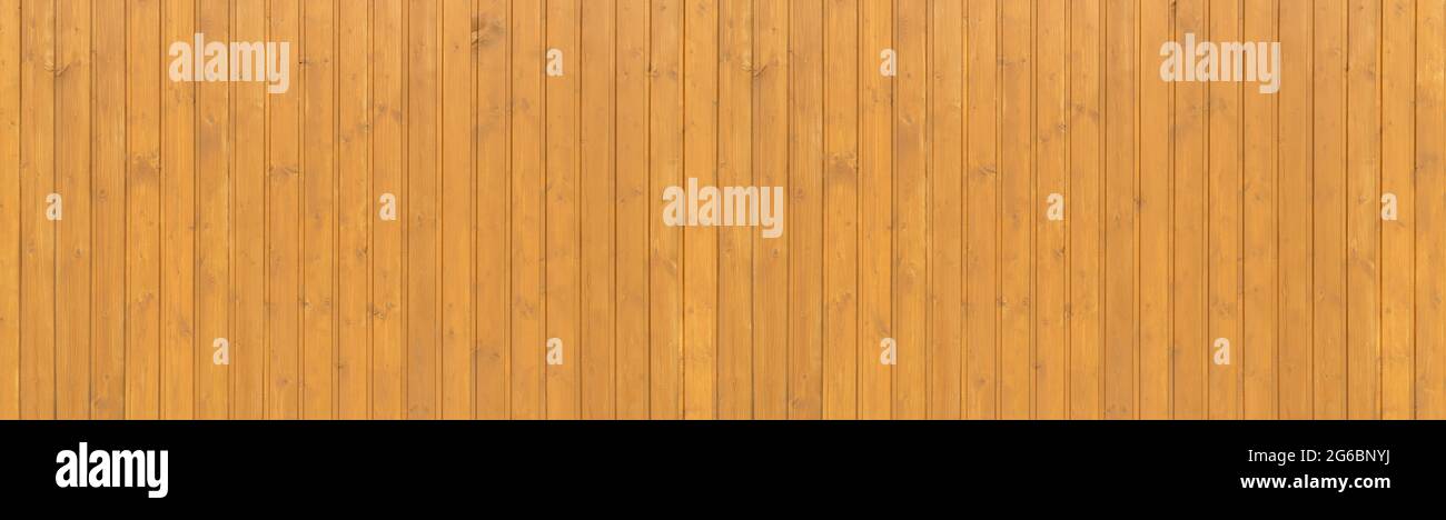 Honey-colored, yellow brown glazed wooden wall in panoramic close-up ...