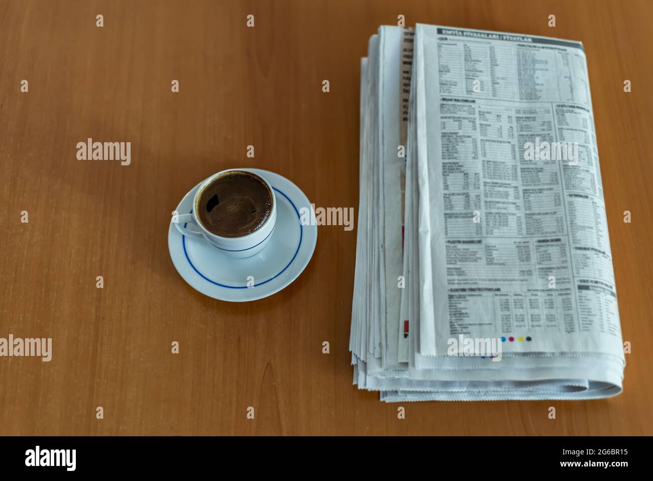 Top view of a cup of Turkish coffee and newspaper on the wooden table ...
