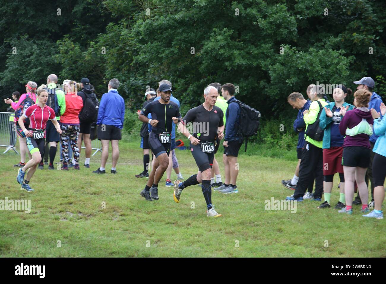 a mixed group of runners in a race watched by spectators Stock Photo ...