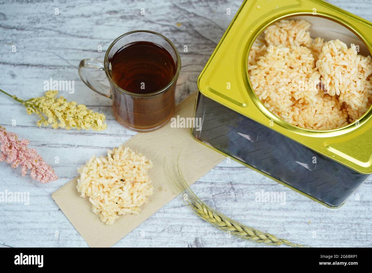 Metal box of rice and a glass of tea on a wooden table Stock Photo - Alamy