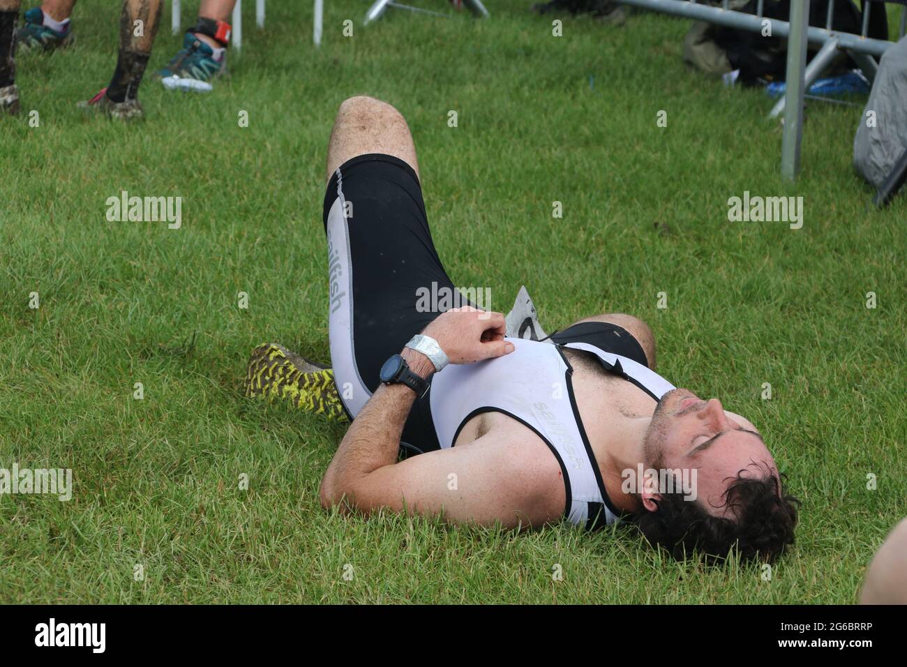 a triathlete collapses on the floor on his back at the end of a race ...
