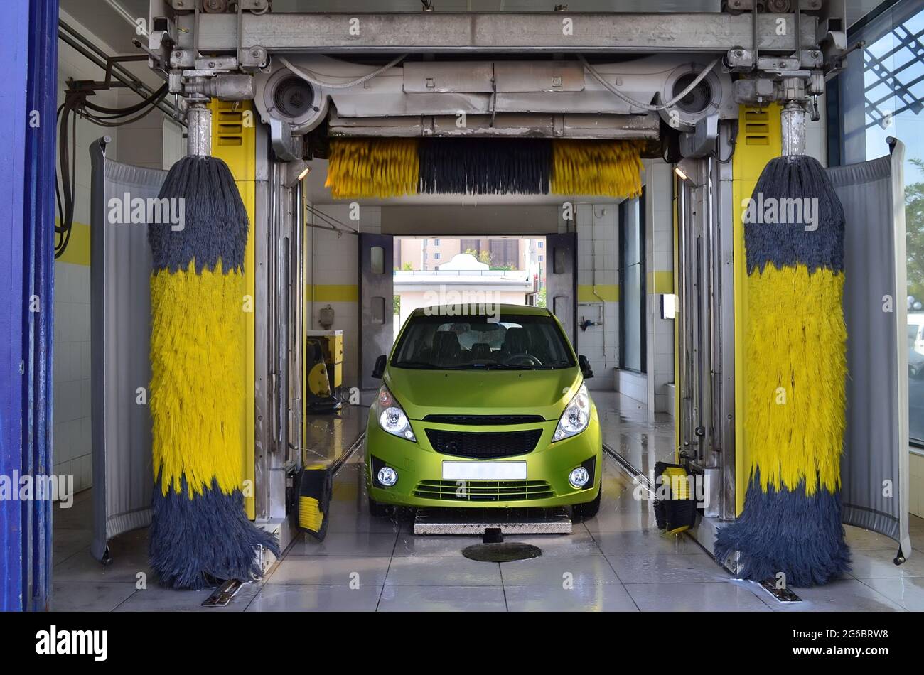 Automatic car wash with washable wet green car Stock Photo - Alamy