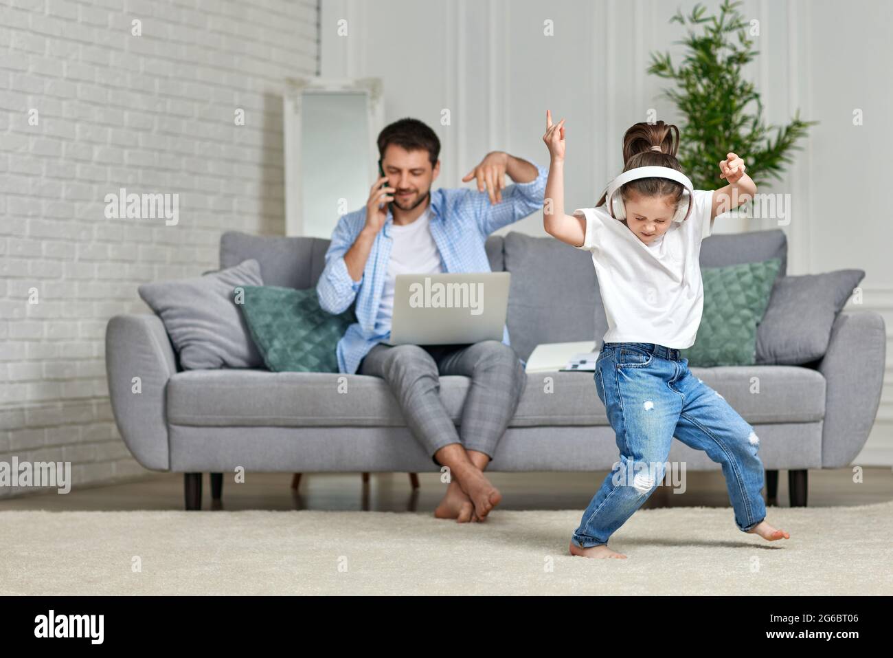 kid dancing and busy dad working with laptop at home Stock Photo - Alamy