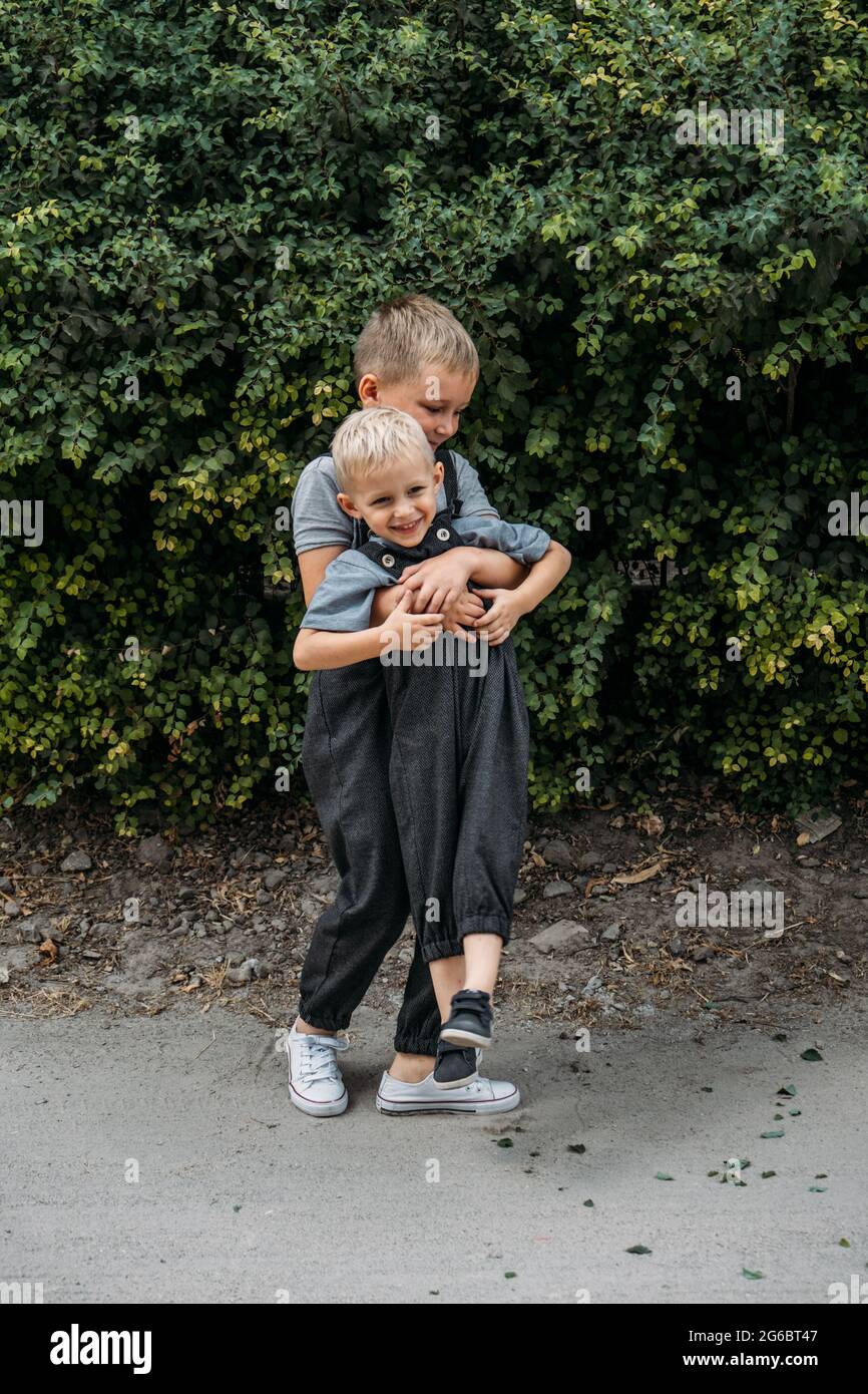Two Brother kids siblings play together near house. Two little boys ...