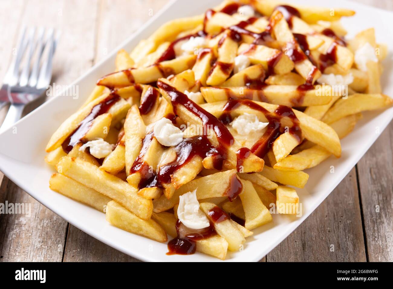 Traditional Canadian Poutine on wooden tablecloseup Stock Photo - Alamy