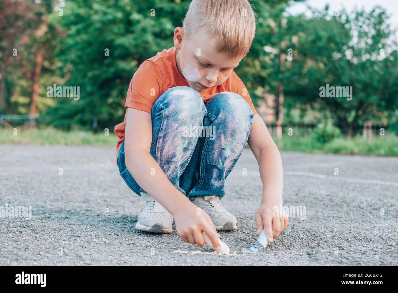 The child drawing on the sidewalk. The face and clothes are stained ...