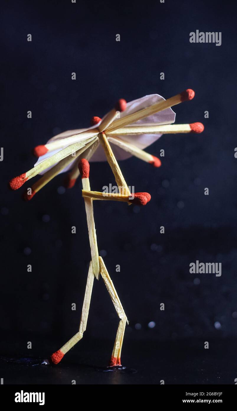 A matchstick man with a matchstick umbrella in the rain. Raining ...