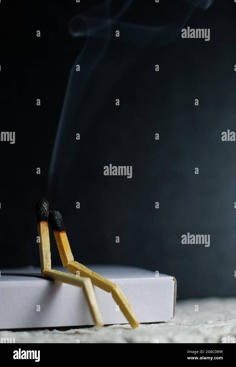 Two matches burning sitting together on the matchbox in the dark copy ...