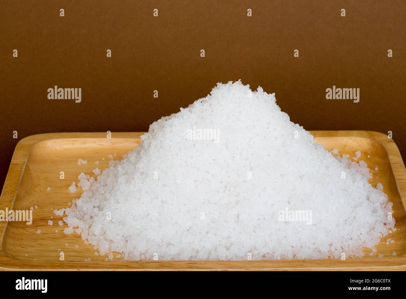 pile of sea salt on wood tray, salt stand out from brown background ...