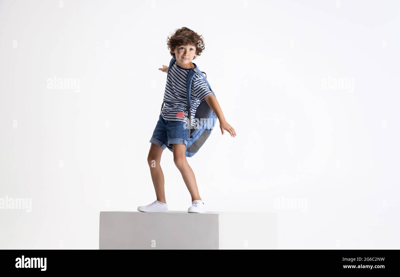 Caucasian preschool boy standing on big box isolated over white studio ...