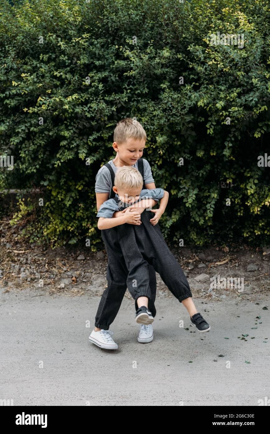 Two Brother kids siblings play together near house. Two little boys ...