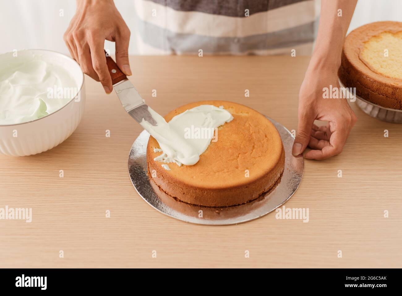 Pastry chef puts the cream on the Cakes. Process cooking sponge cake ...