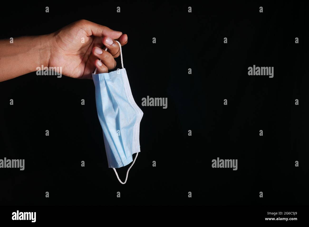 man hand holding surgical face mask isolated on black Stock Photo - Alamy