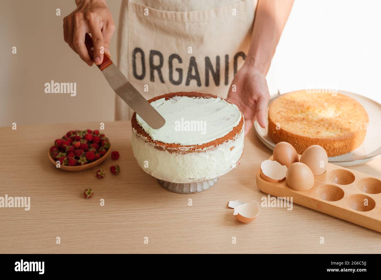 Putting the cream on top of sponge cake. Making sponge cake series ...