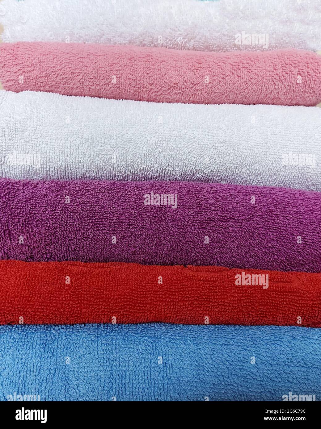 Multi-colored cotton terry towels are stacked. Home textile background ...
