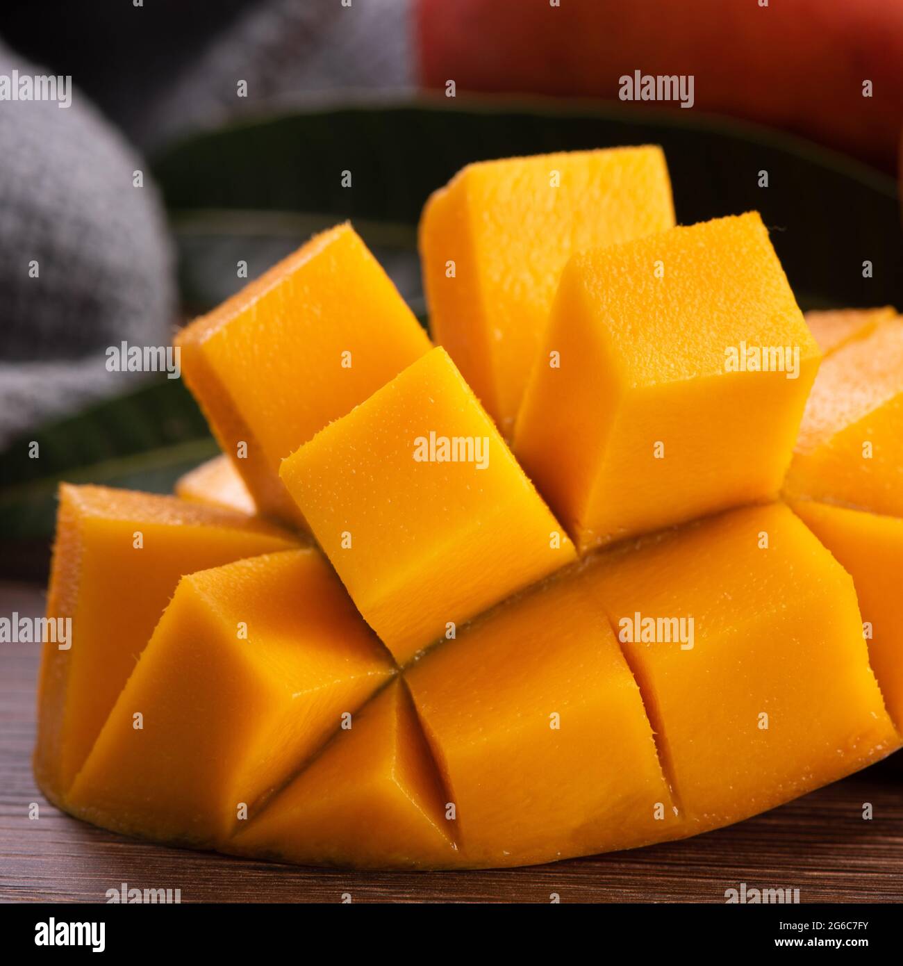 Mango. Close up of fresh ripe mango fruit with leaves over dark wooden ...