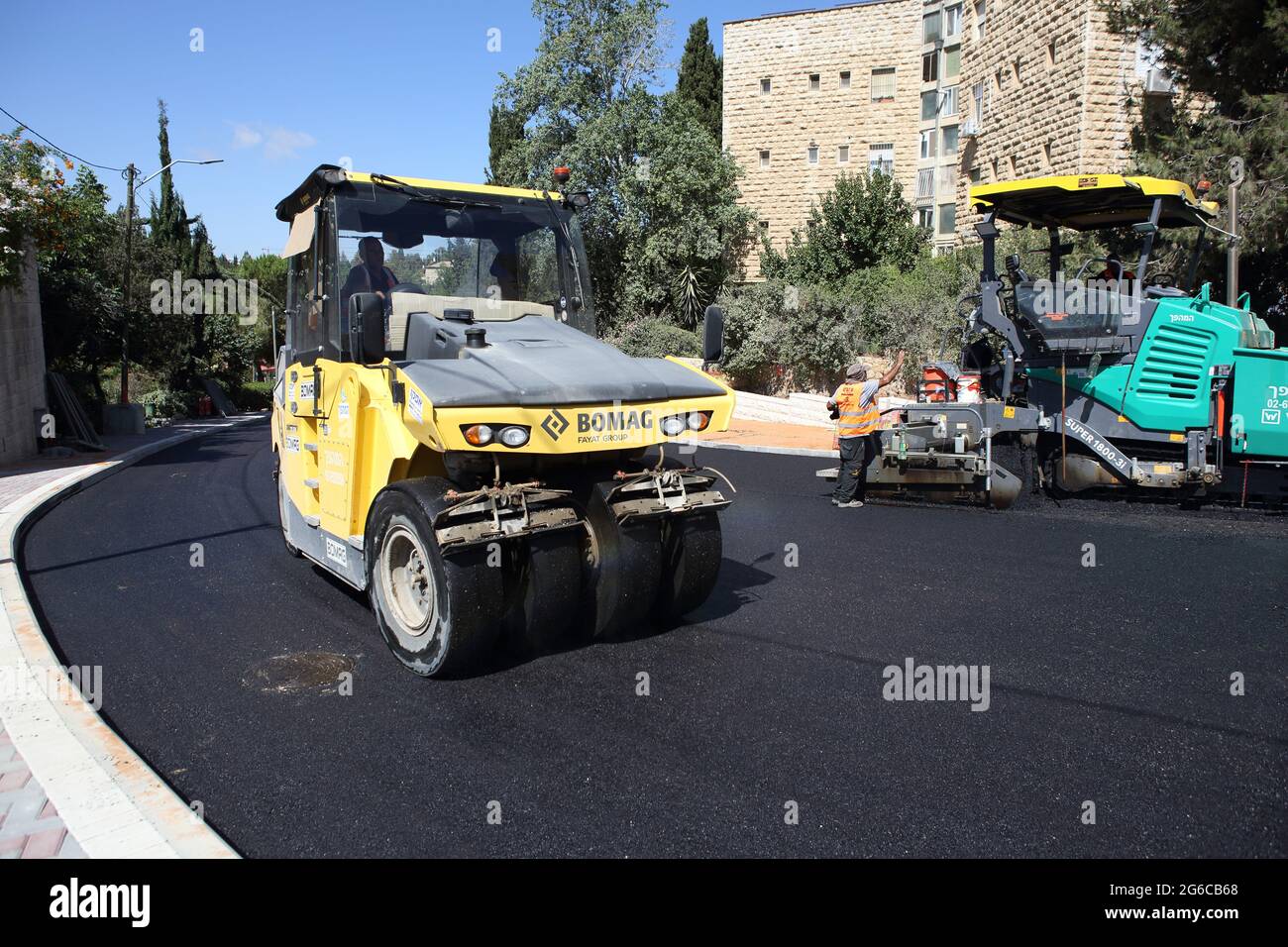 Pneumatic Road Roller pressing the freshly laid asphalt layers by the ...