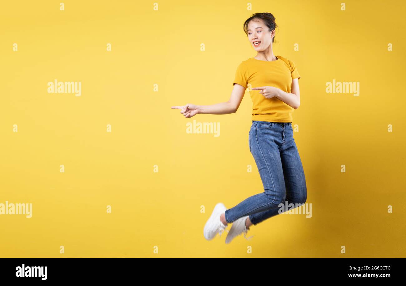 Full length portrait of cheerful girl jumping up isolated on yellow ...