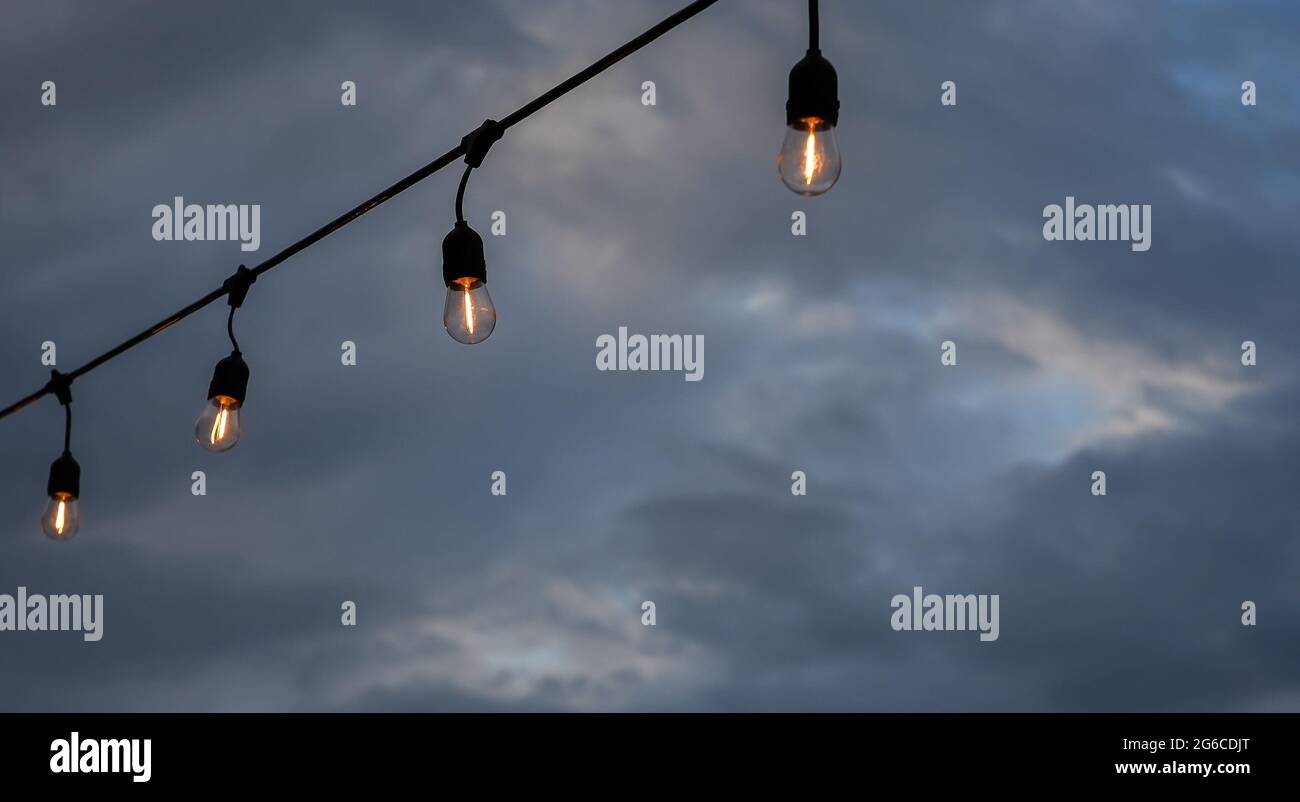 Light bulbs with cloudy evening sky background Stock Photo - Alamy
