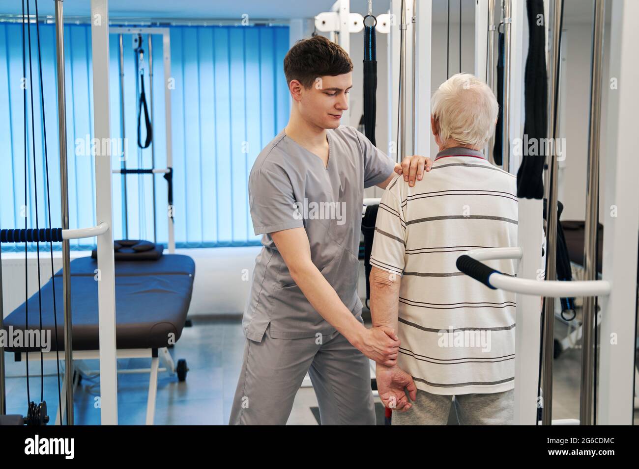 Physician developing muscles of left arm for aged male Stock Photo - Alamy