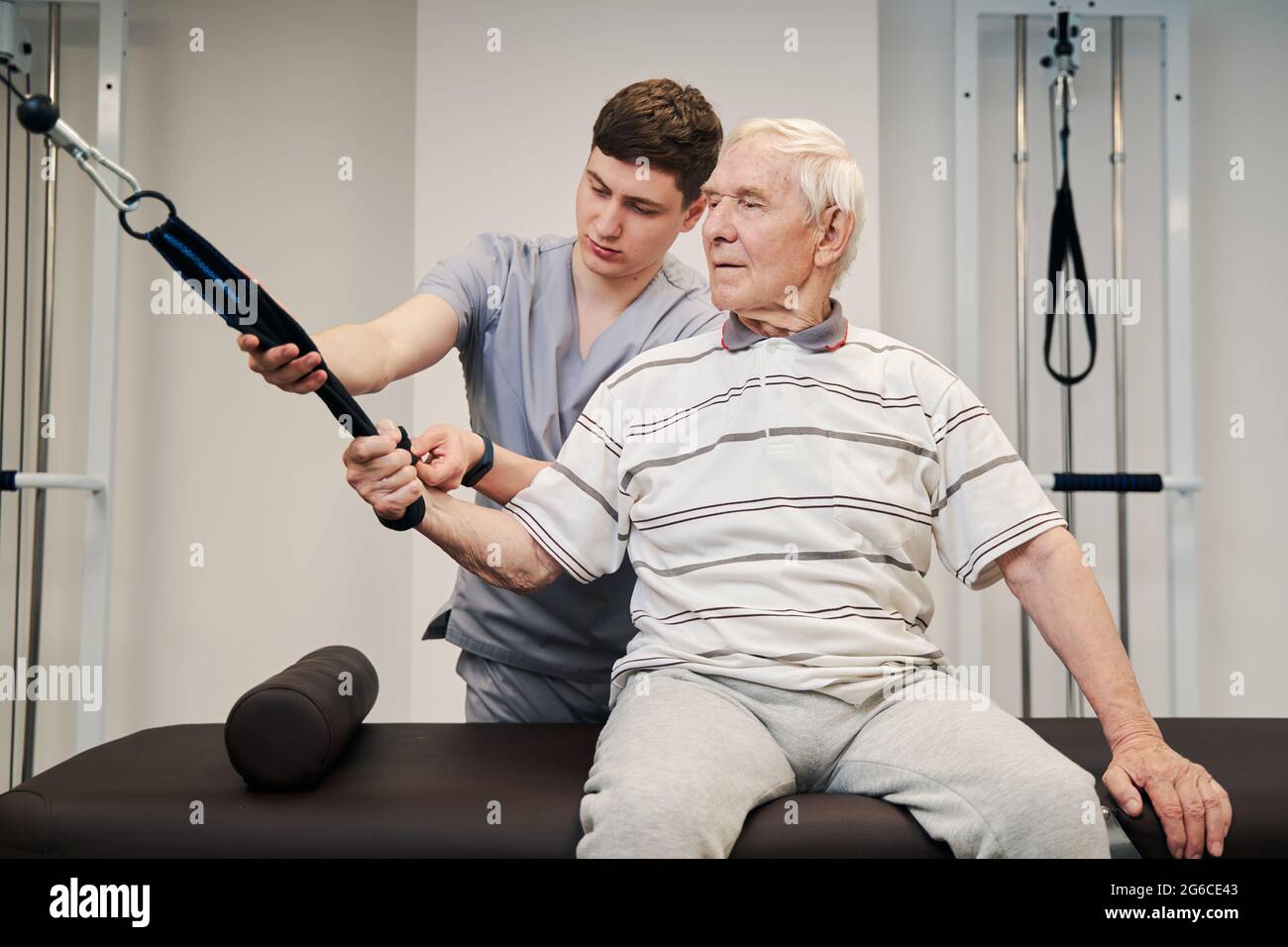 Senior patient on couch pulling resistance band with right hand Stock ...