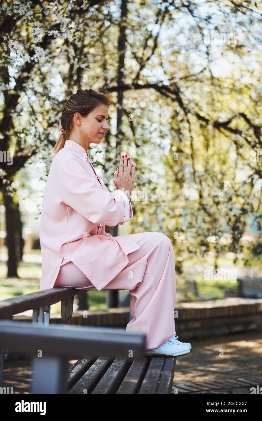 Woman sitting sideways while meditating with praying gesture Stock ...