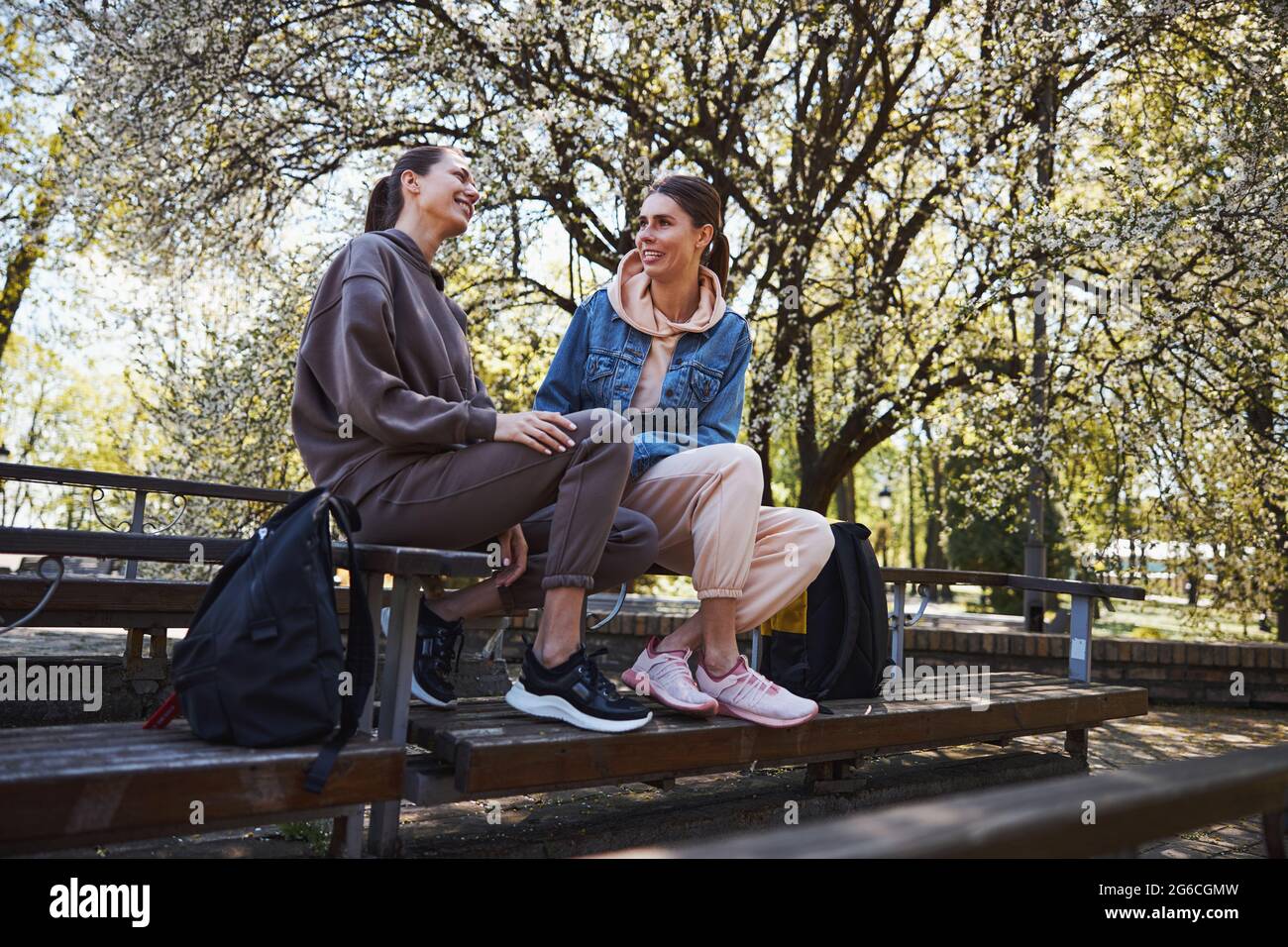 Female in jacket giving an interested look at smiling woman Stock Photo ...