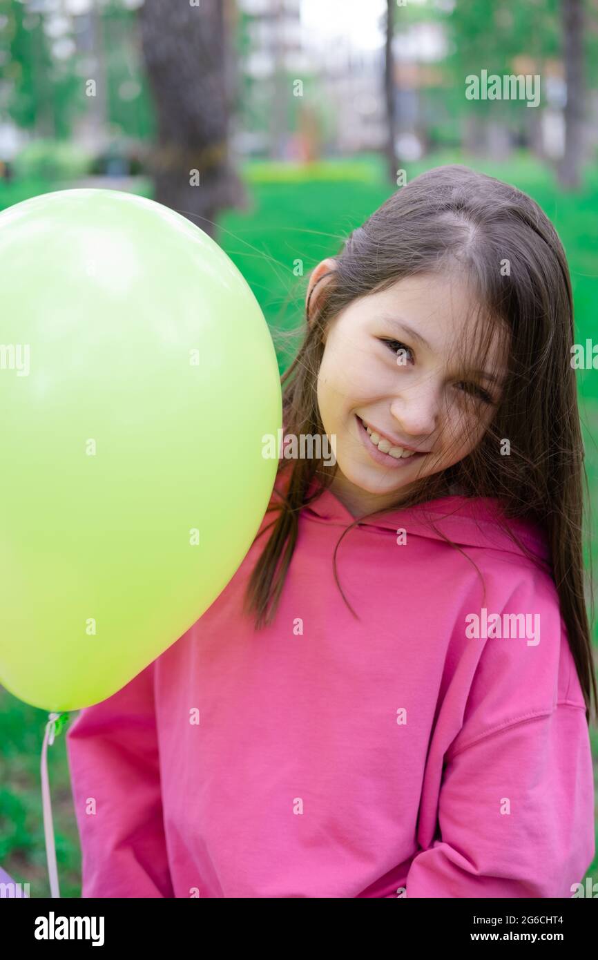 pretty tween teenager brunette girl in pink holding colorful hot air ...