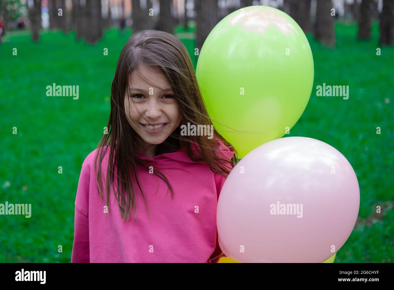pretty tween teenager brunette girl in pink holding colorful hot air ...
