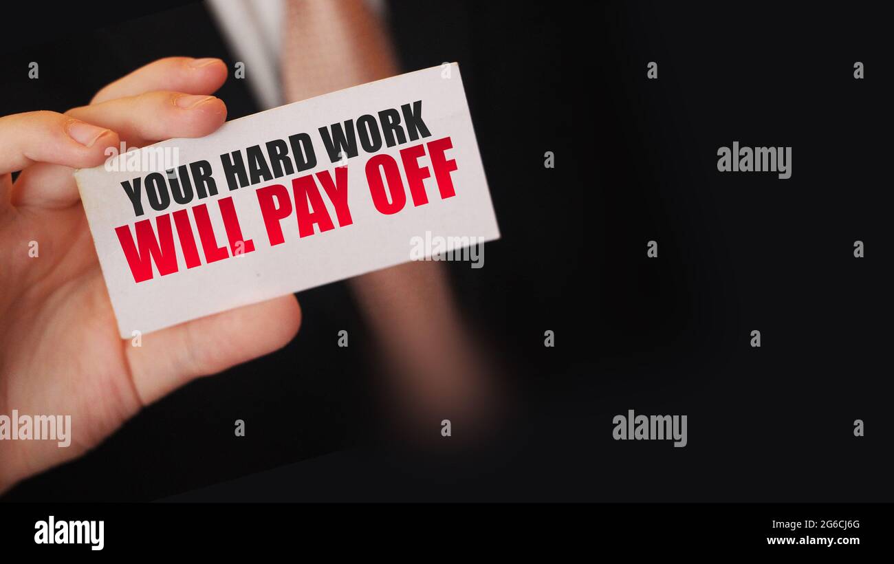 Your Hard Work Will Pay Off inspirational text on card in businessman ...
