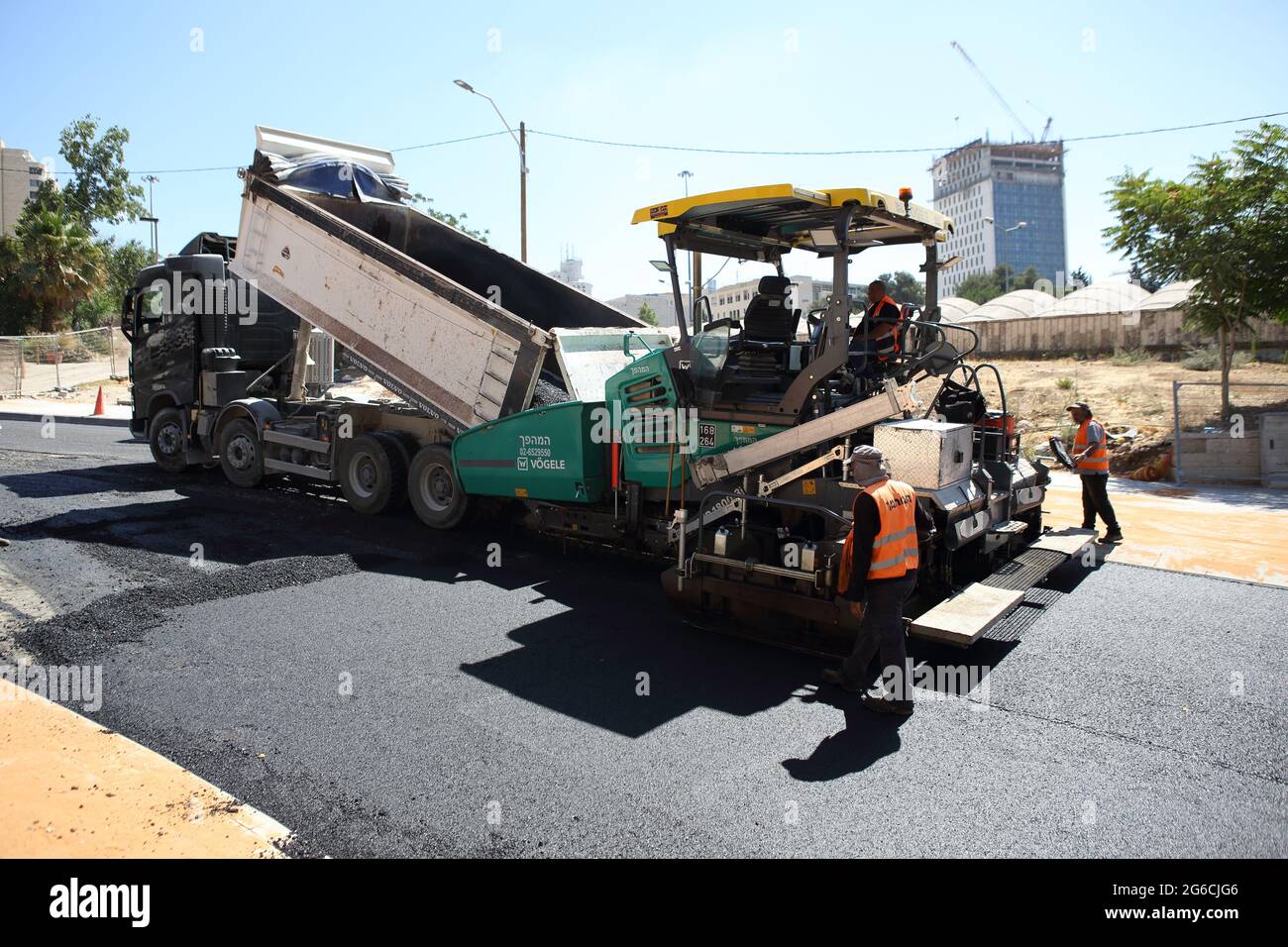 Left, a truck pouring the asphalt into the Asphalt Paver Finisher that ...