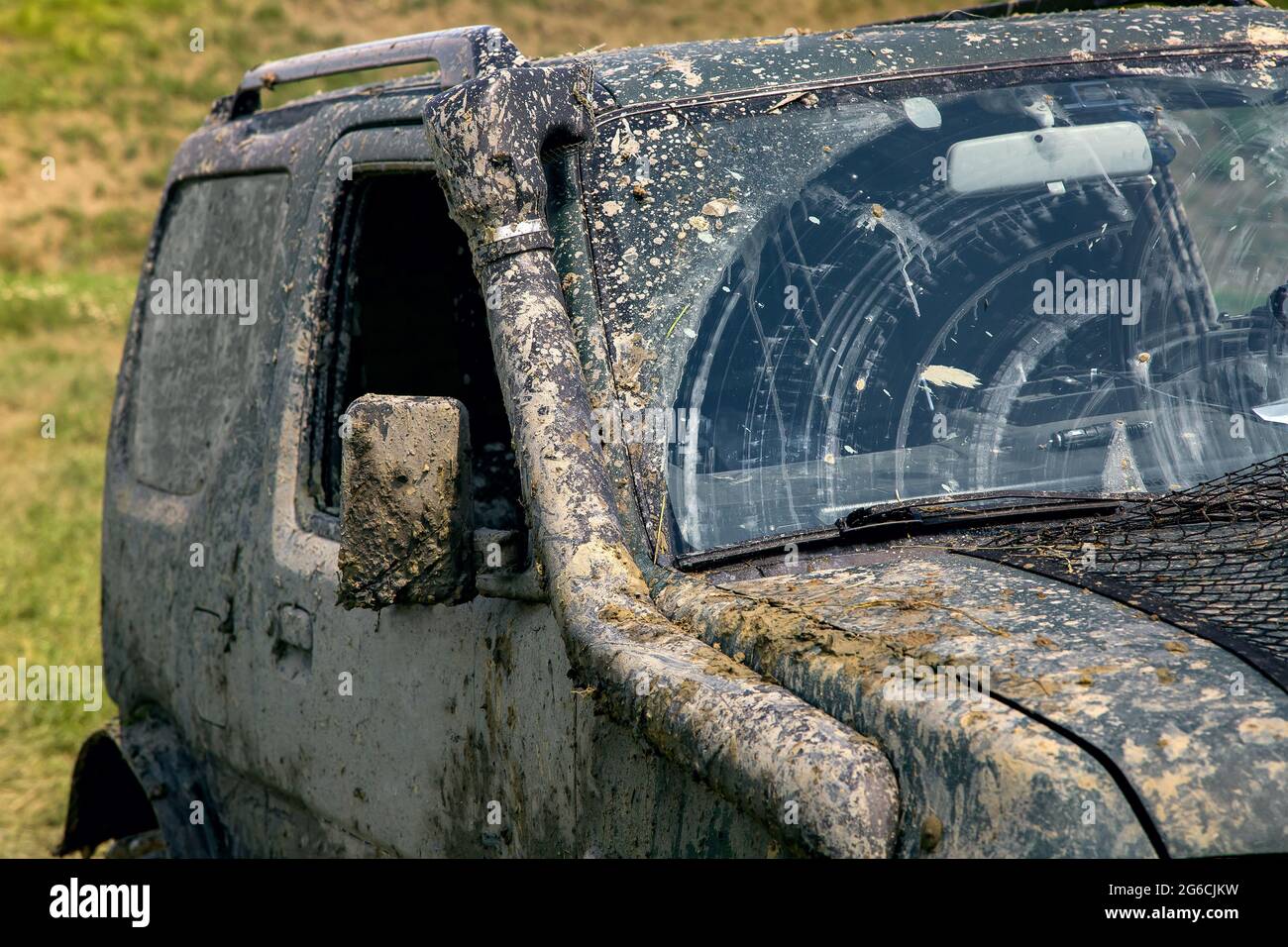 a dirty car covered with a layer of swamp spray as a result of off-road ...
