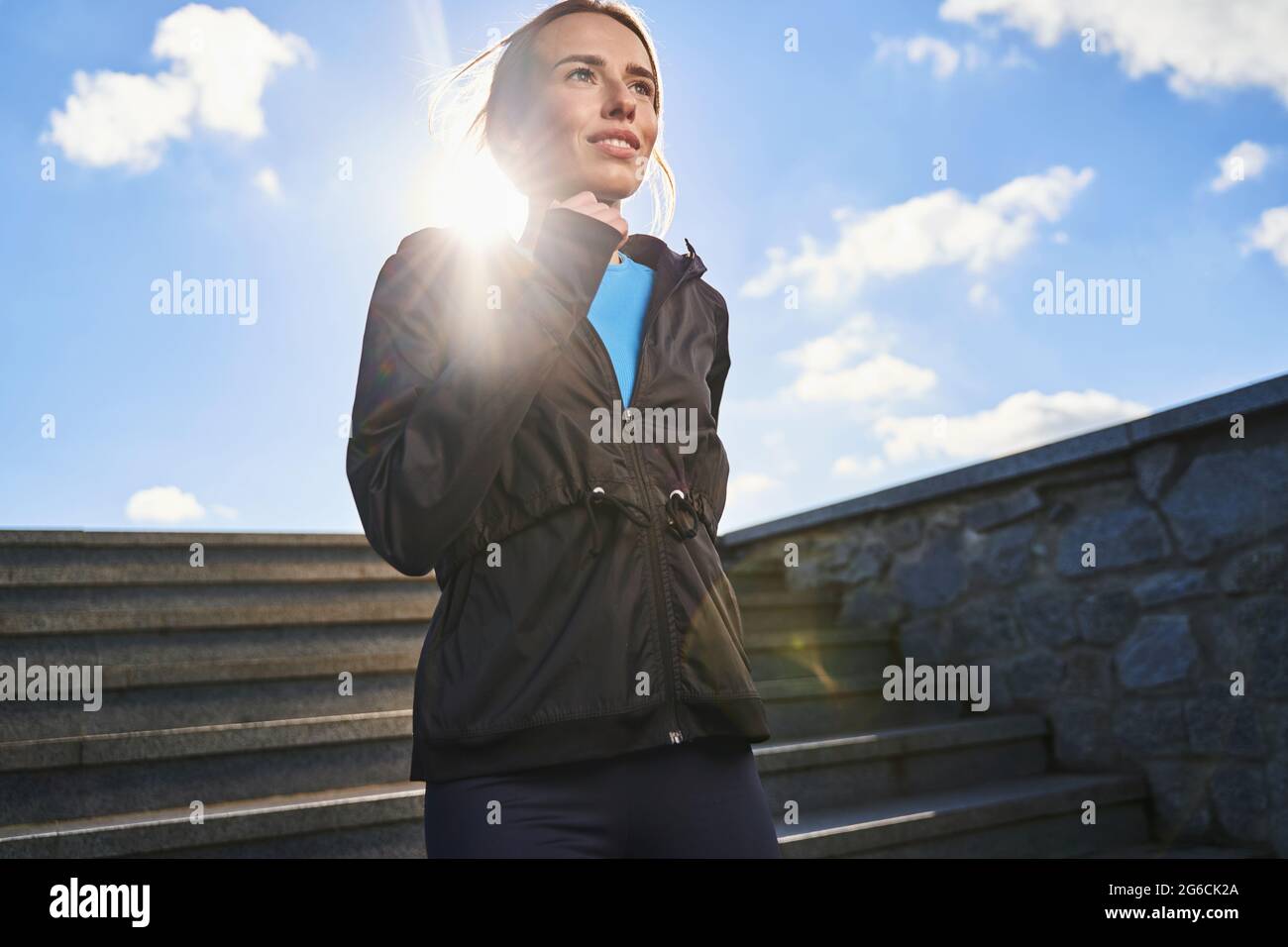 Smiling woman running during sunny day outdoors Stock Photo - Alamy