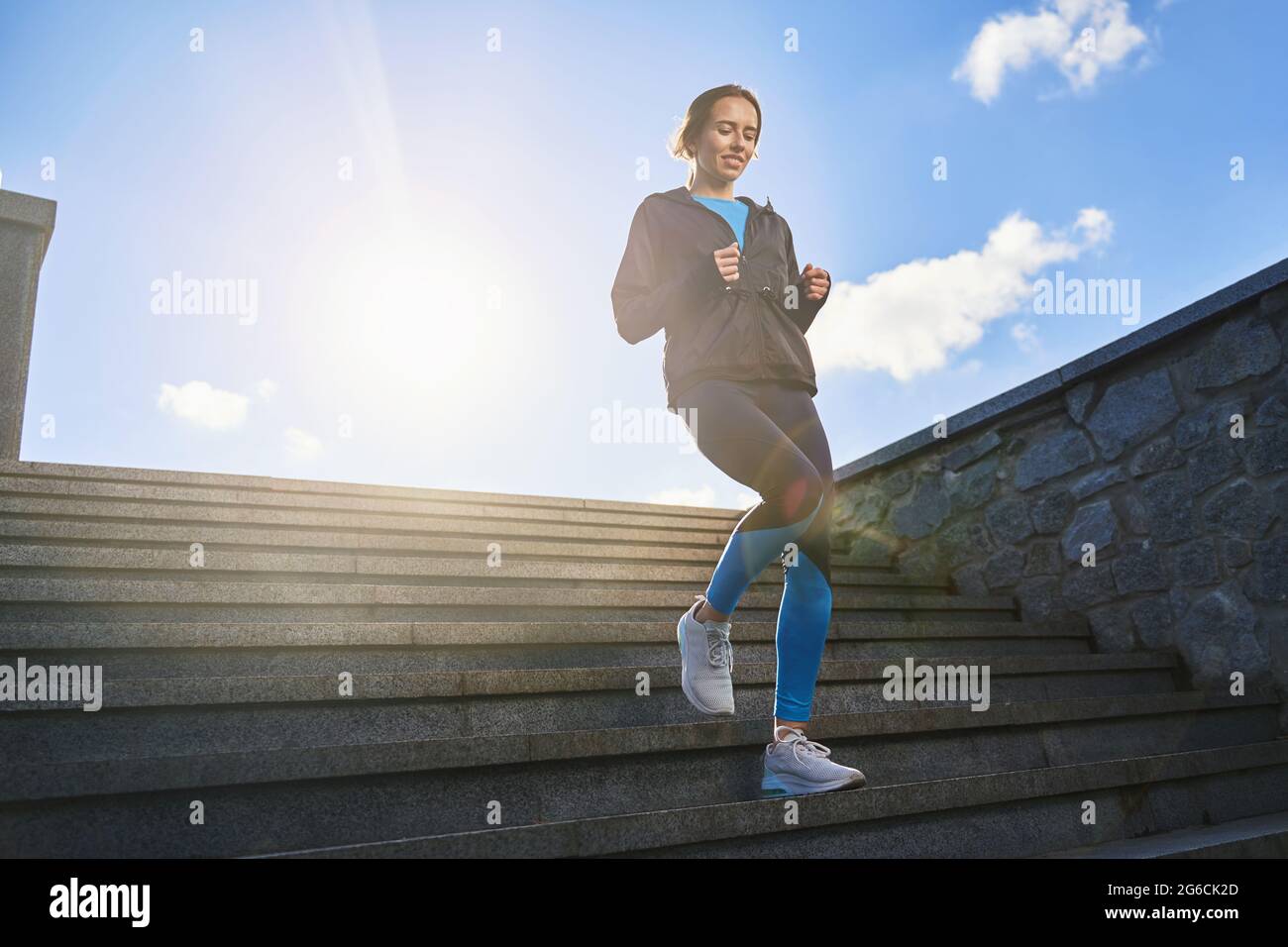 Smiling fit woman going jogging in city Stock Photo - Alamy