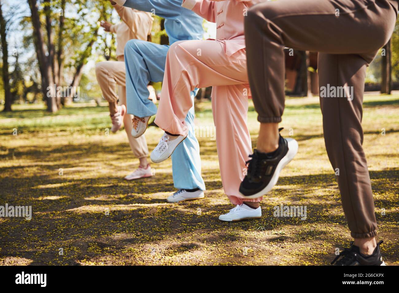 Raised legs of four people, doing exercise in park Stock Photo - Alamy