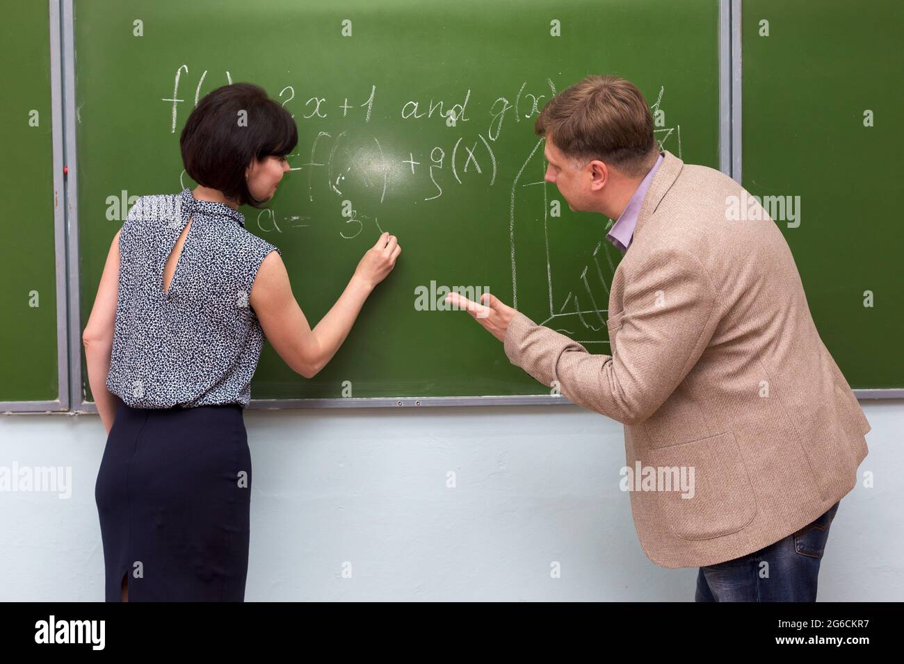 The teacher explains to the student the solution of math problem at the ...
