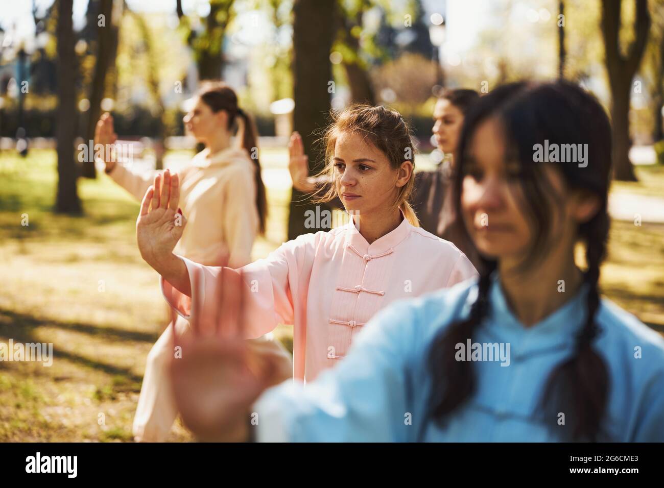 Females pushing arm forward with open palm during tai chi Stock Photo ...