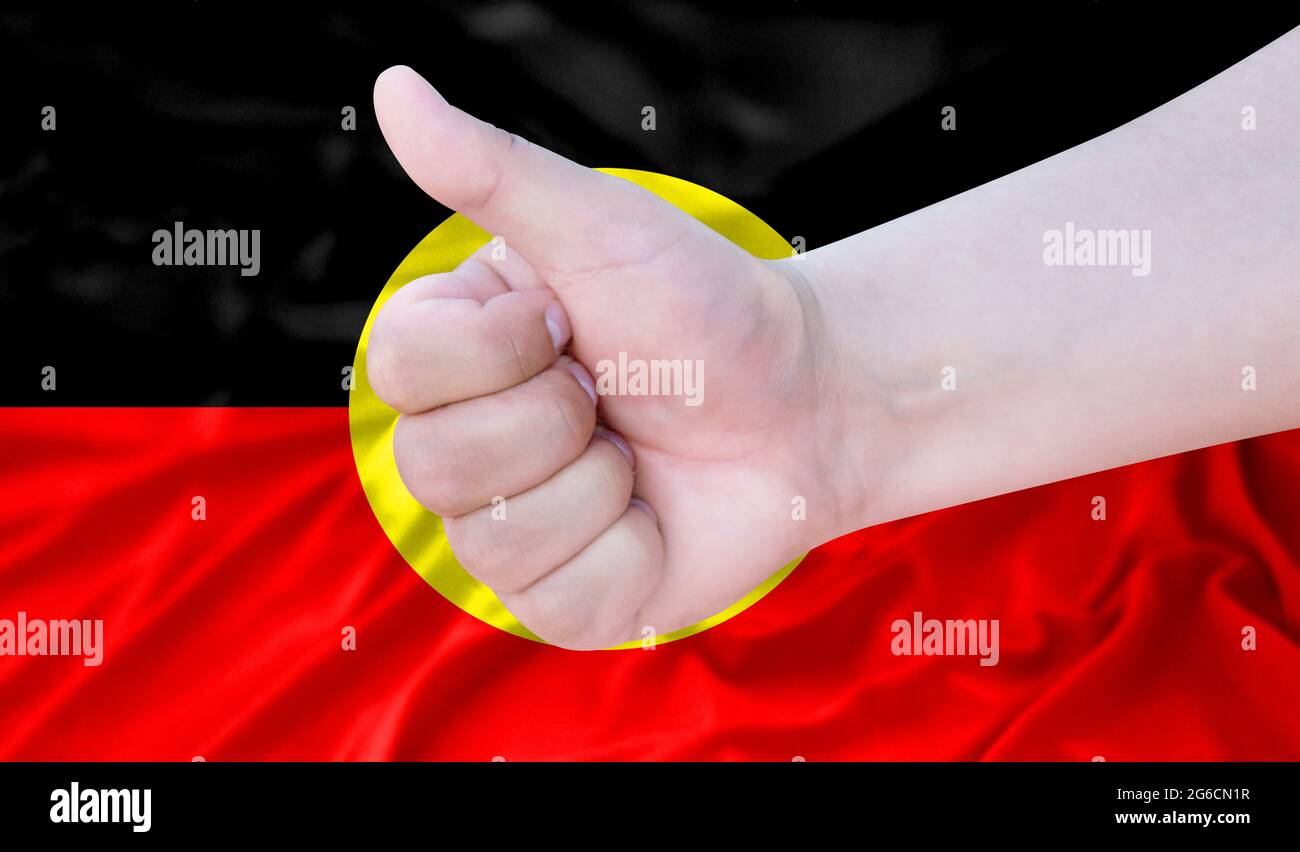 Hand makes a thumbs up sign on the background of the flag of Australian ...