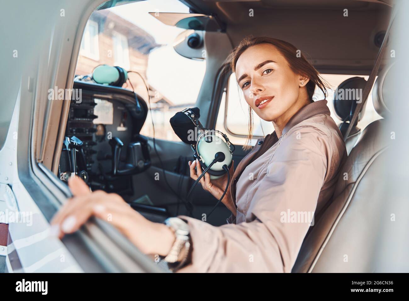 Nice young woman sitting in aircraft pilot cabin Stock Photo - Alamy