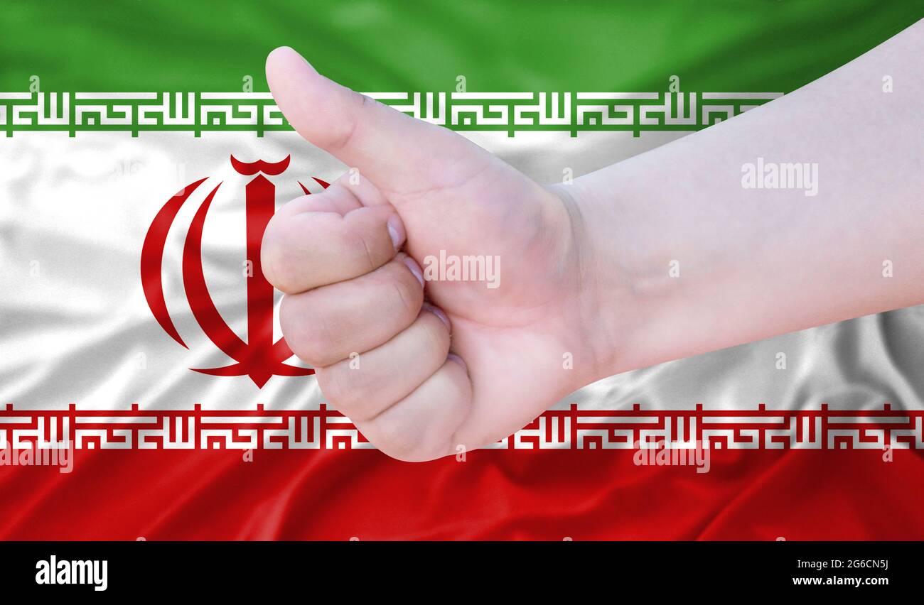 Hand makes a thumbs up sign on the background of the flag of Iran. like ...