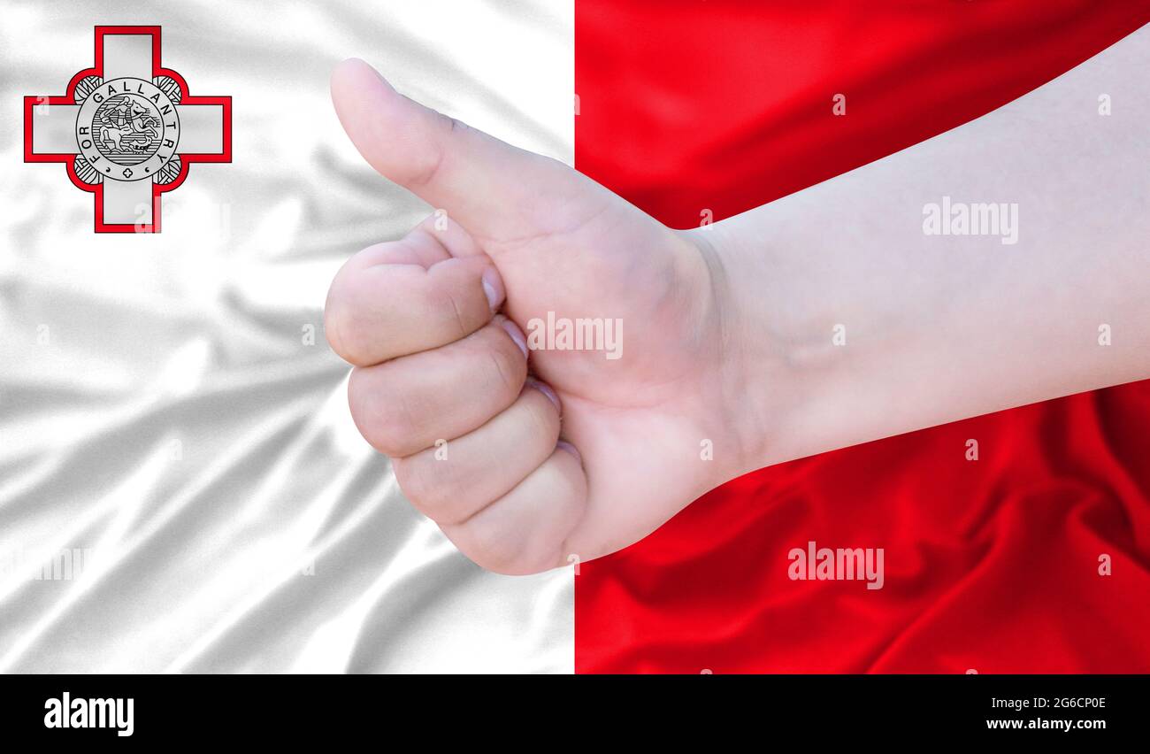 Hand makes a thumbs up sign on the background of the flag of Malta ...
