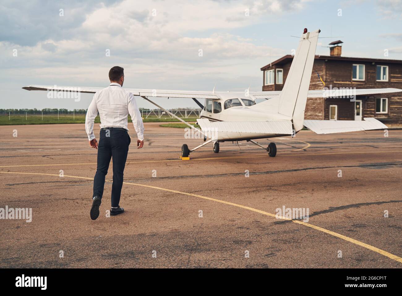 Stylish young man walking towards aircraft at airdrome Stock Photo - Alamy