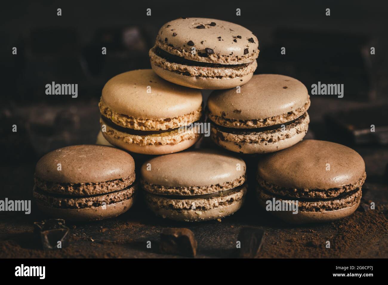 Stacked brown macarons on dark background Stock Photo - Alamy