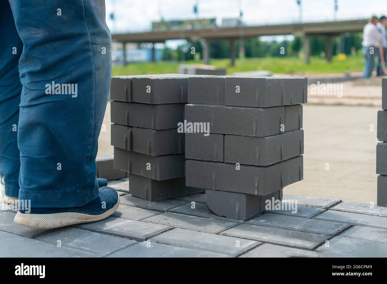 Man's feet are standing near a large number of concrete bricks on the ...
