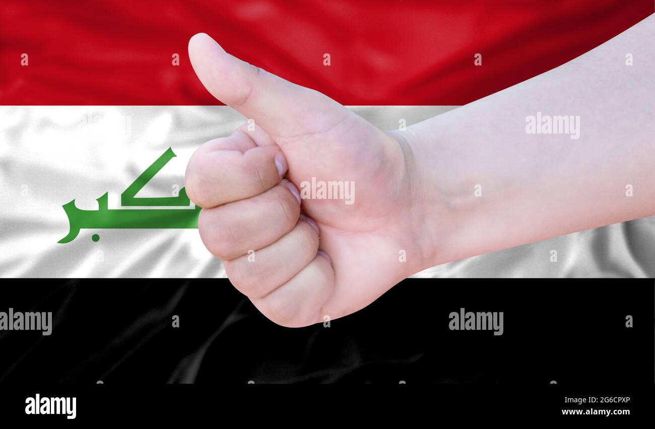 Hand makes a thumbs up sign on the background of the flag of Iraq. like ...