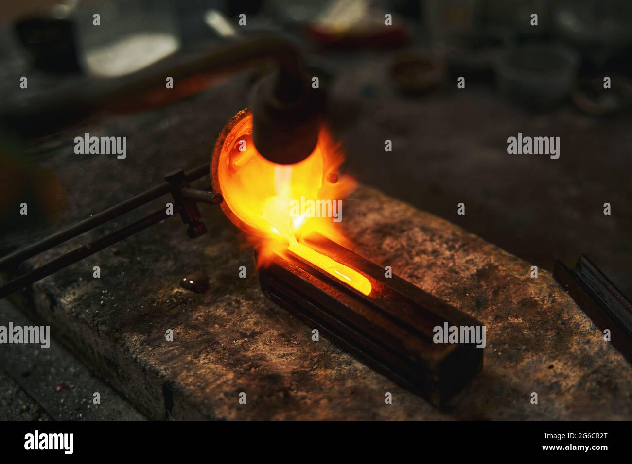 Goldsmith pouring melted metal into the mold Stock Photo - Alamy